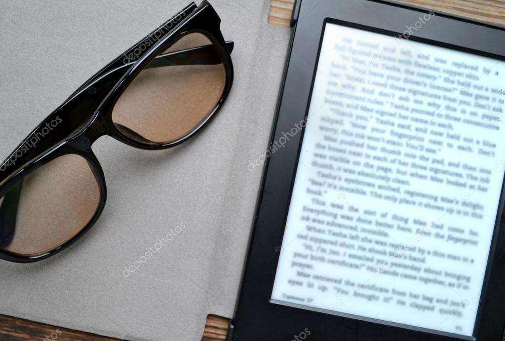 Black ereader with retro glasses on wooden table Stock Photo by ...