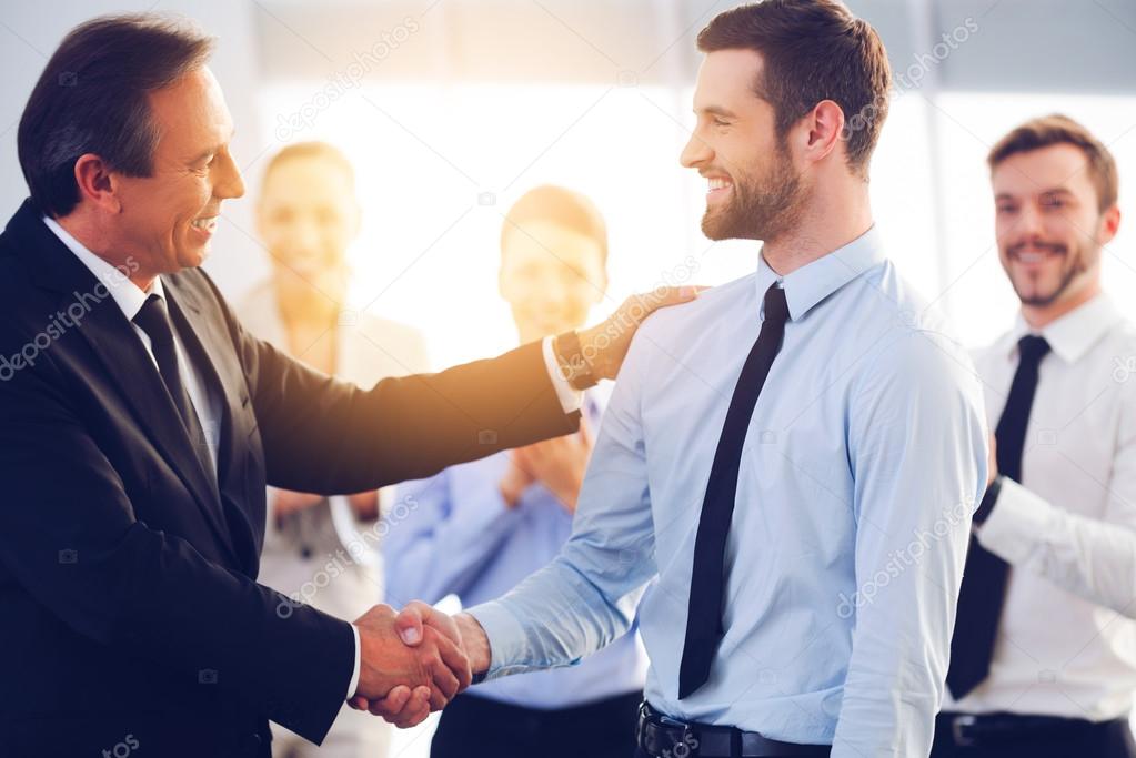Cheerful businessmen shaking hands — Stock Photo © gstockstudio #104839276