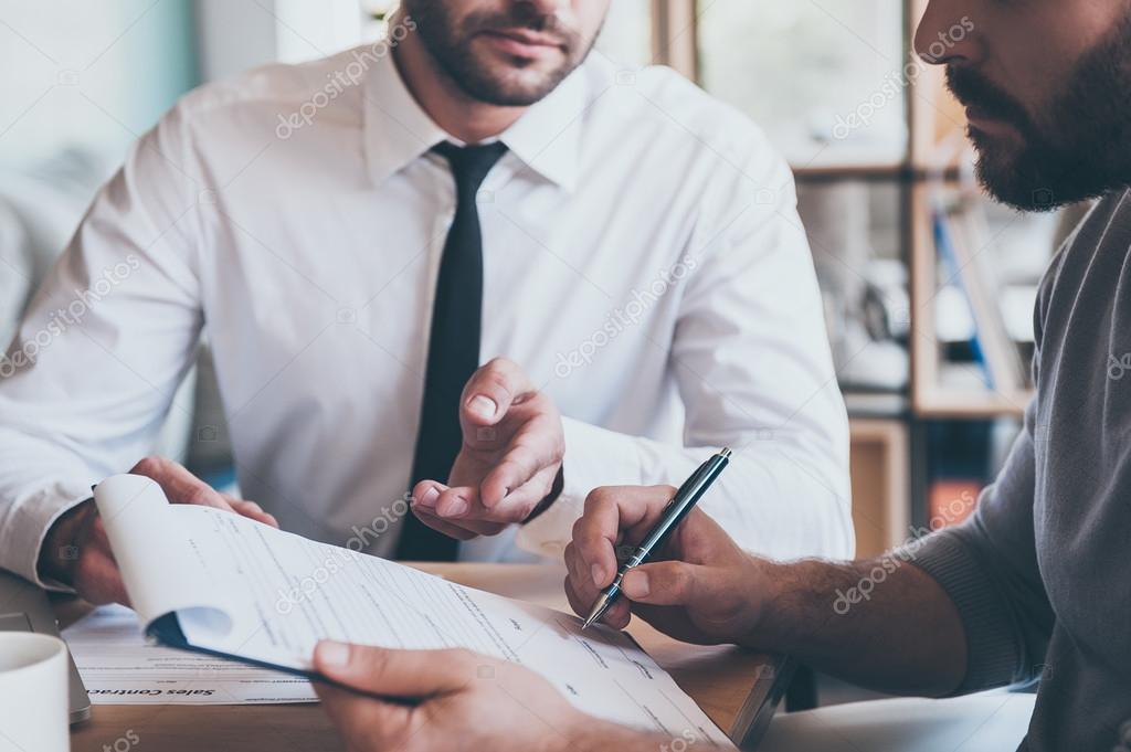 Two men signing papers Stock Photo by ©gstockstudio 111977884