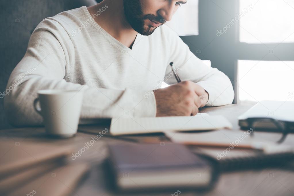 Young man writing notes in diary — Stock Photo © gstockstudio #123186552