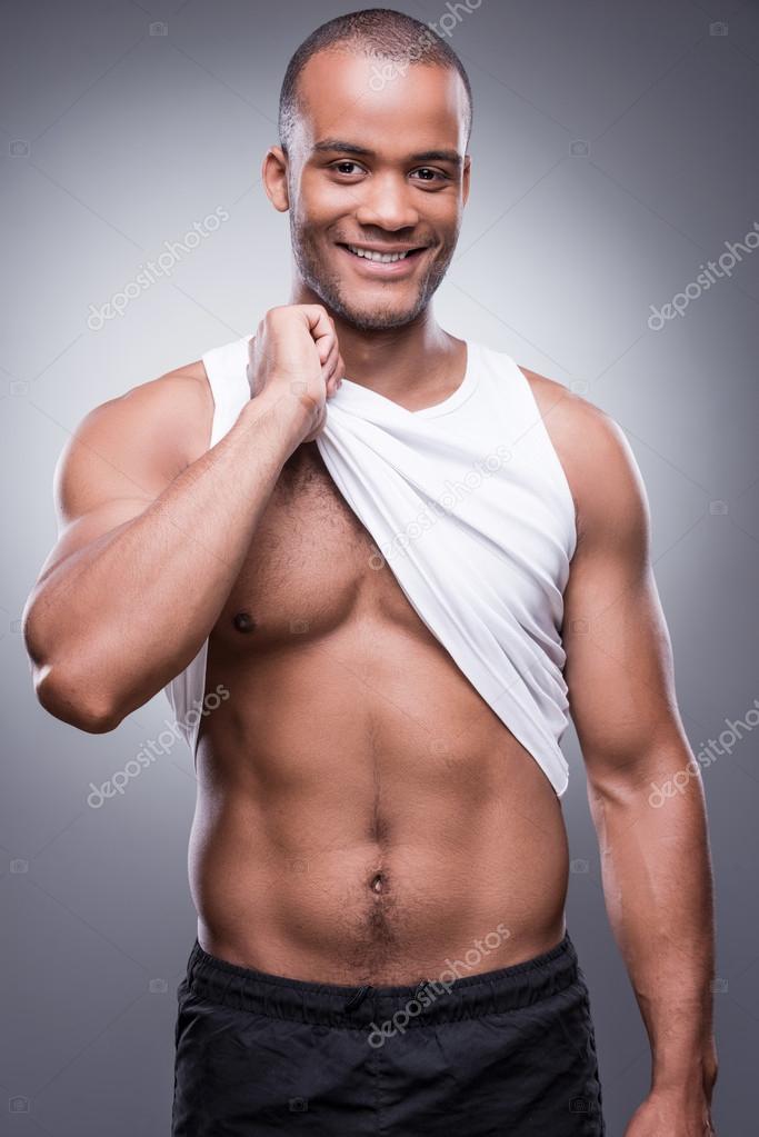 African man taking off his tank top Stock Photo by ©gstockstudio 51859477