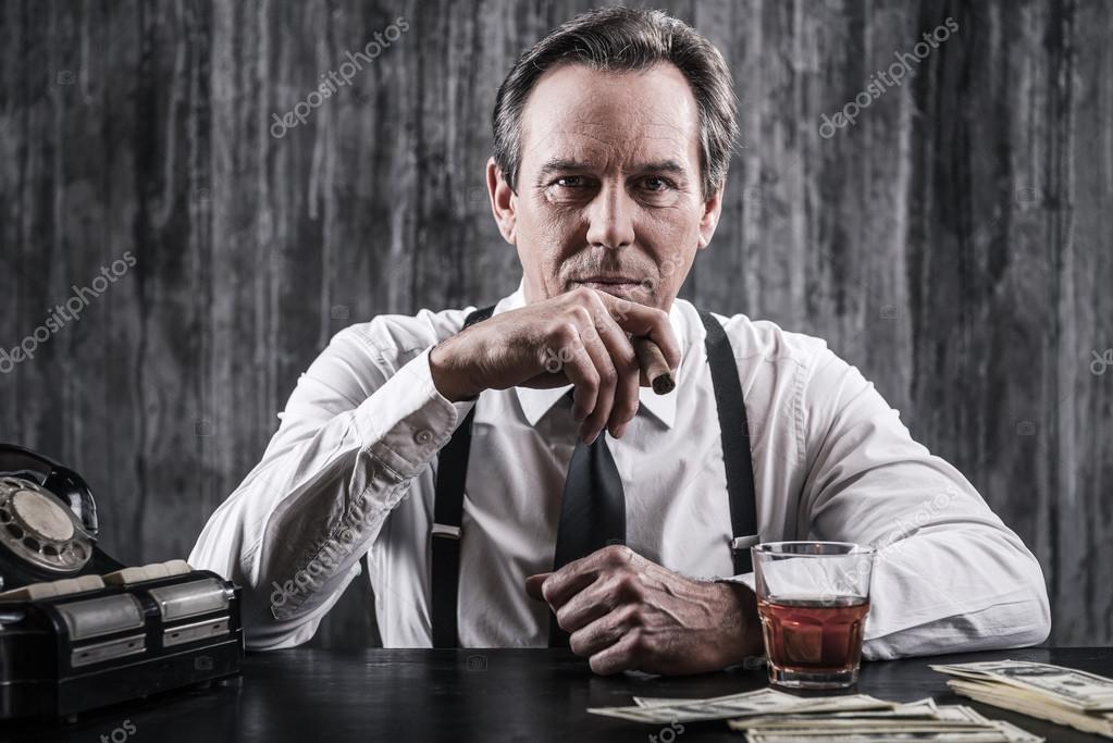 Man sitting at the table and smoking cigar — Stock Photo © gstockstudio ...