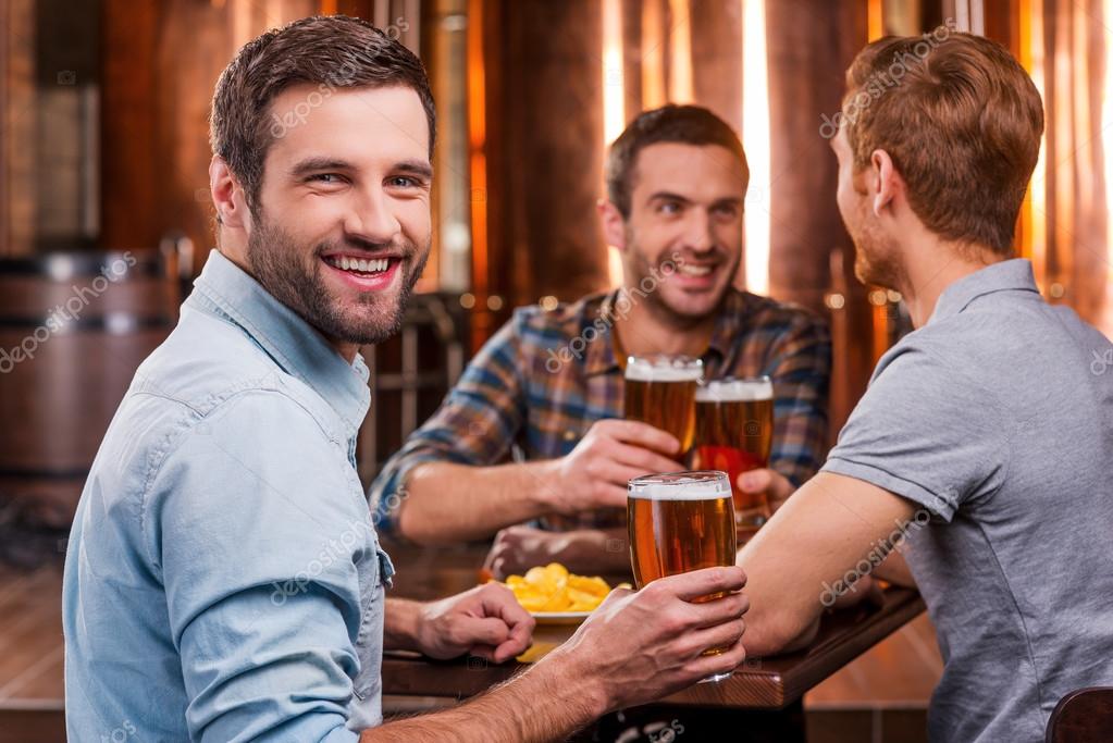 Young man toasting with beer — Stock Photo © gstockstudio #61925393