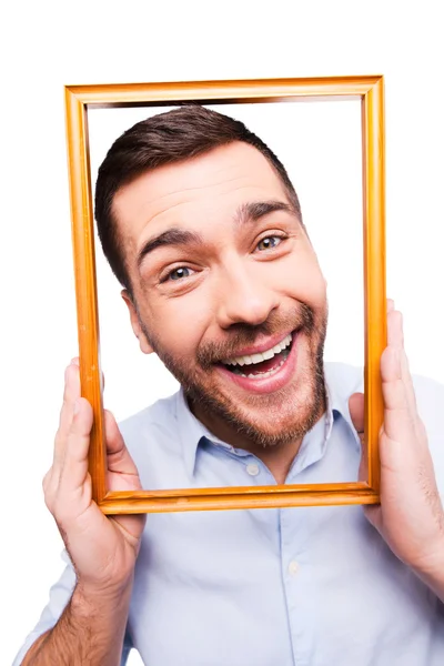 Young man holding picture frame Stock Photo by ©gstockstudio 62630115