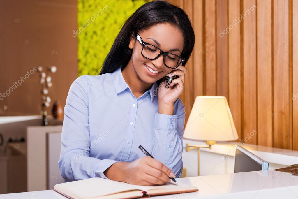 African woman making notes in note pad — Stock Photo © gstockstudio ...
