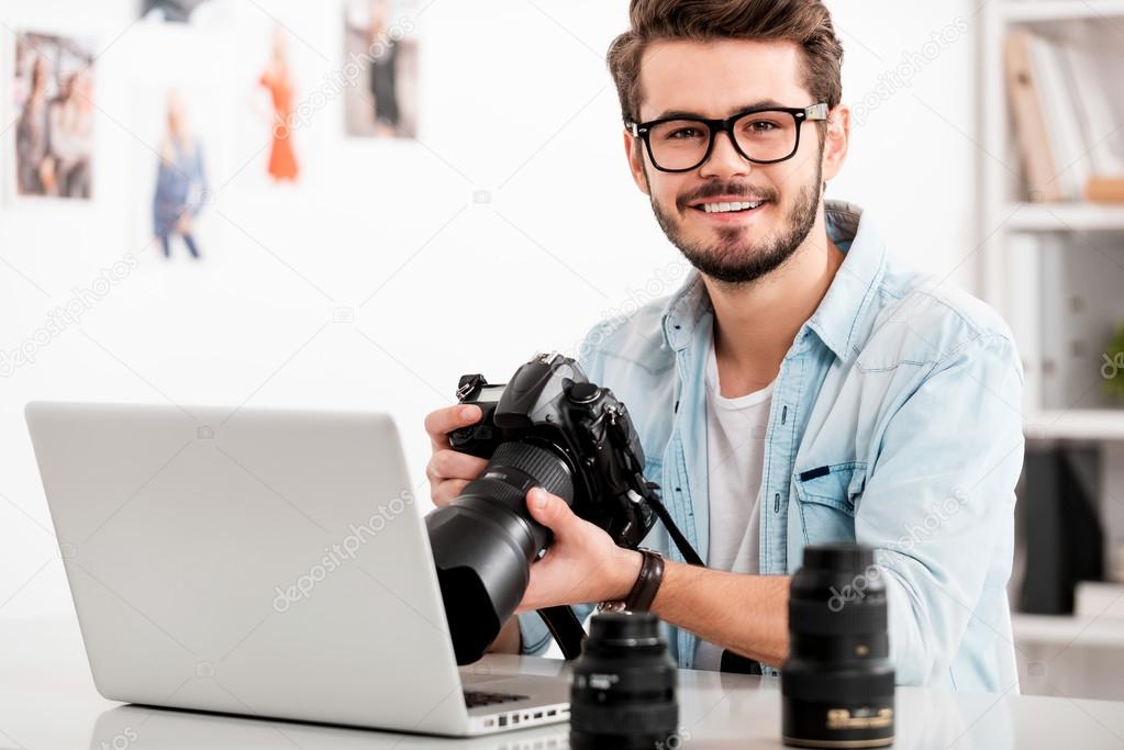 Happy young man holding camera — Stock Photo © gstockstudio #74908629
