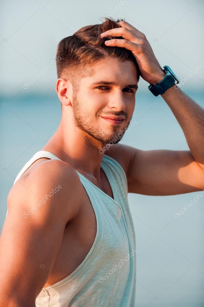Muscular man holding hand in hair Stock Photo by ©gstockstudio 77924944