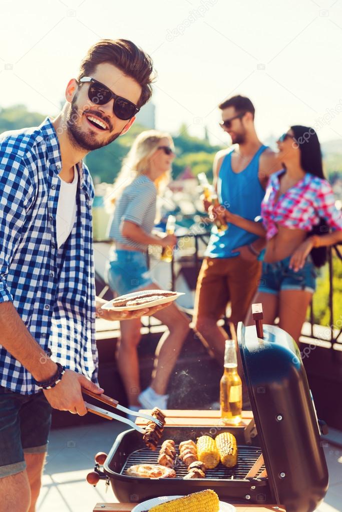 Happy young man barbecuing Stock Photo by ©gstockstudio 80946500