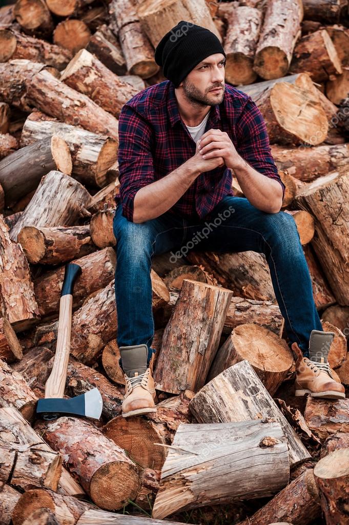 Thoughtful young forester sitting on logs Stock Photo by ©gstockstudio ...
