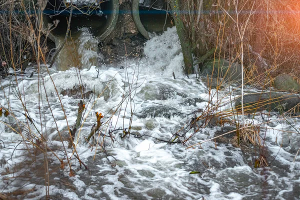 swirling streams of thawed spring water passing through drainage pipes ...
