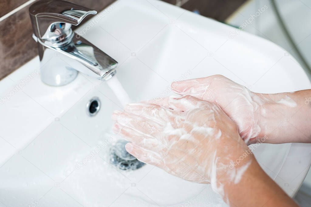 Concepto de higiene. Lavarse las manos con jabón debajo del grifo con ...