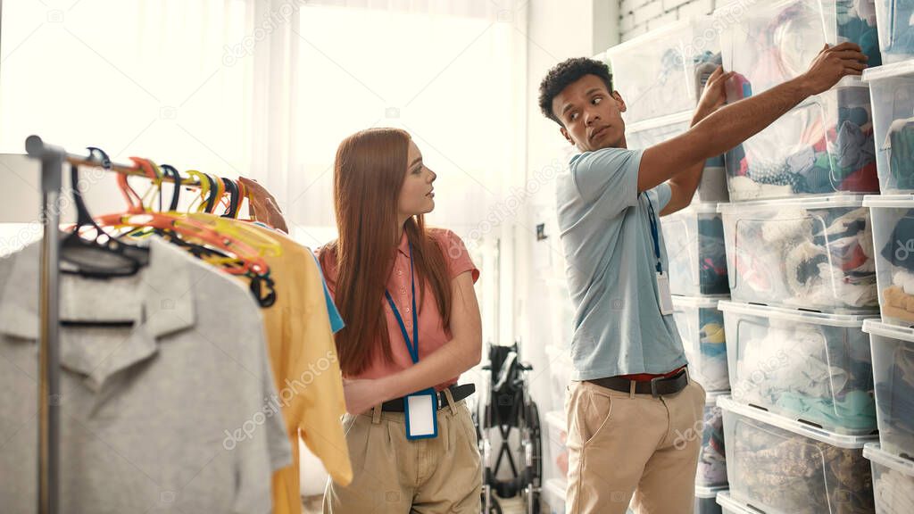 Jóvenes voluntarios clasificando, empacando ropa para personas ...