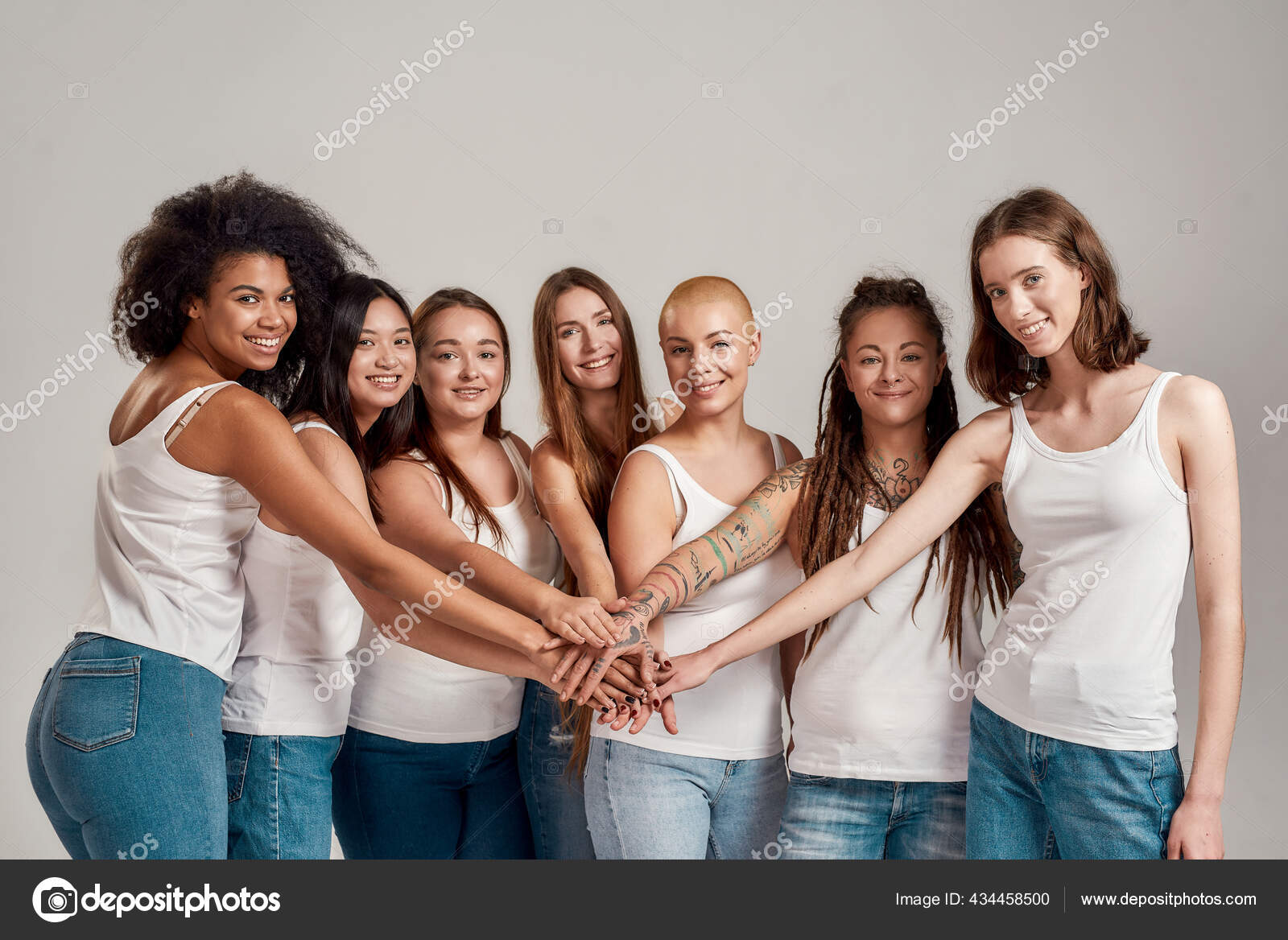 Group of diverse women showing unity, putting their hands on top of ...