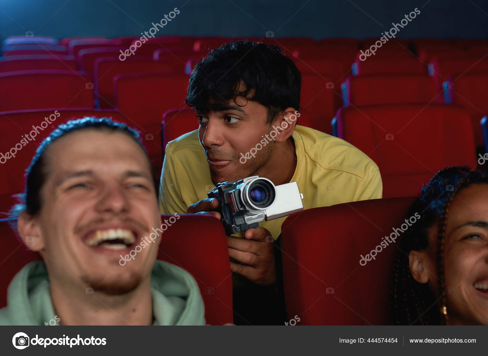Portrait of young guy using his video camera for recording a pirated ...