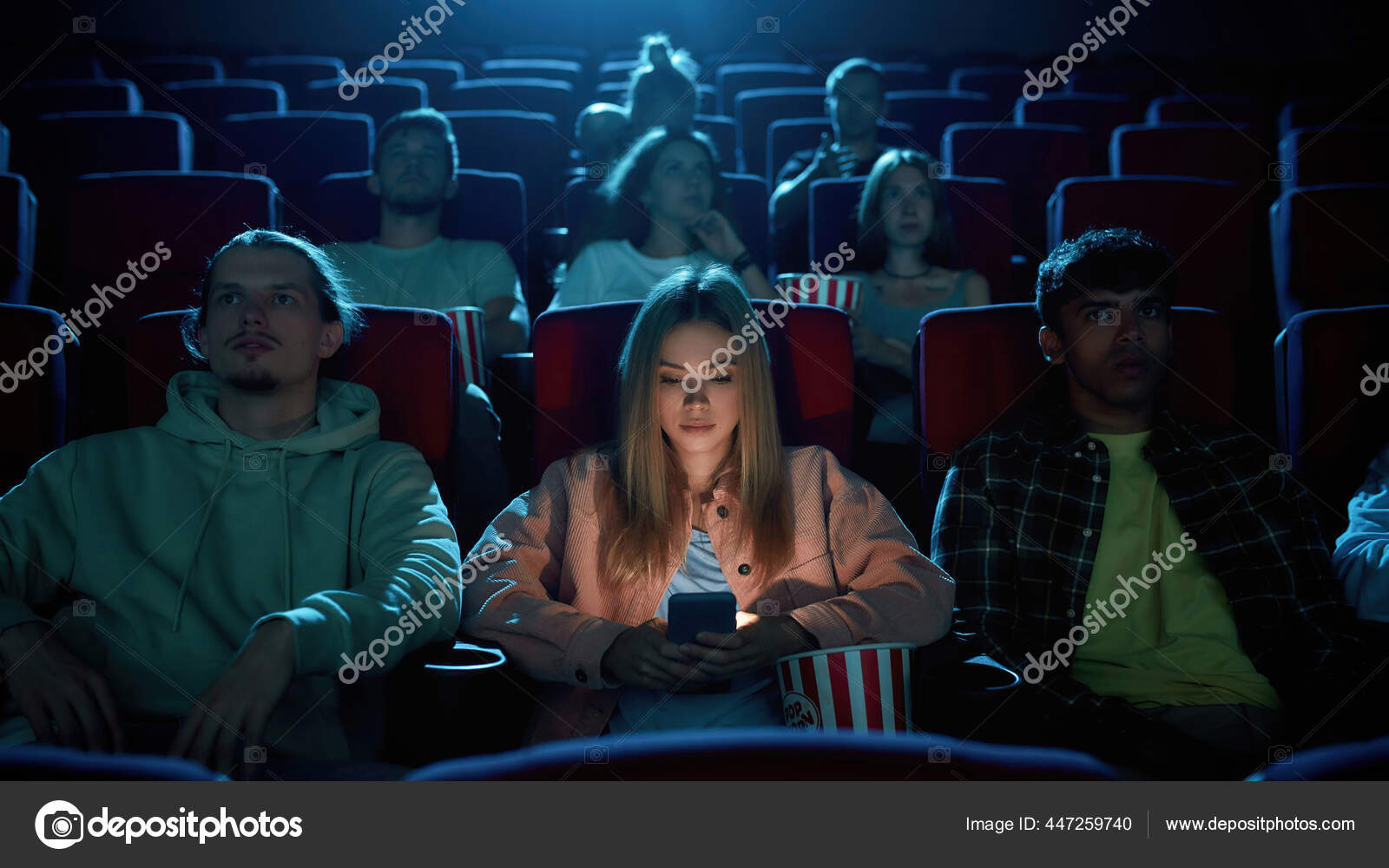 Beautiful young woman using her phone for texting while watching a ...