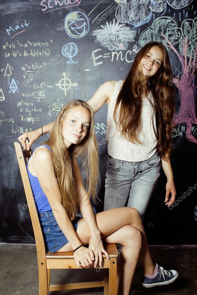 Back to school after summer vacations, two teen girls in classroom with ...