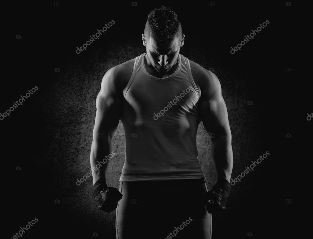 Handsome young man after a workout on a dark background Stock Photo by ...
