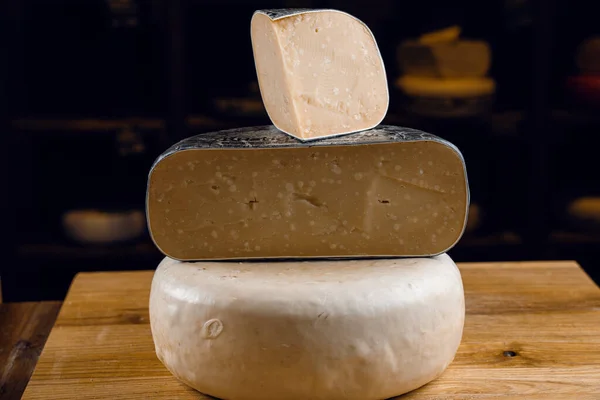 Goat cheese wheel and big pieces of it. Mix of cheeses from goat milk ...