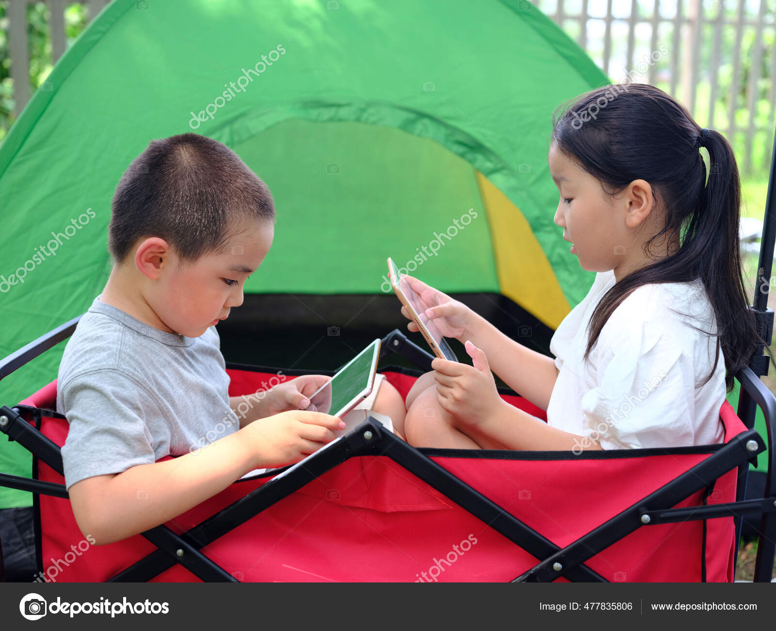 Two happy kids playing computer with tablets Stock Photo by ...