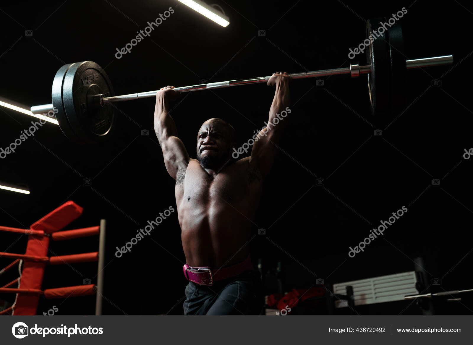 Heavyweight man training with a barbell. Bodybuilding trainer lifts ...