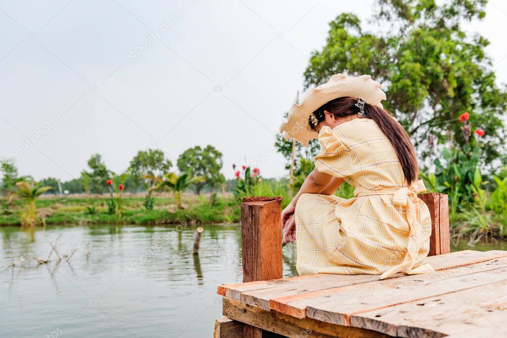 Vista lateral de una niña triste abrazando sus rodillas sollozando con ...