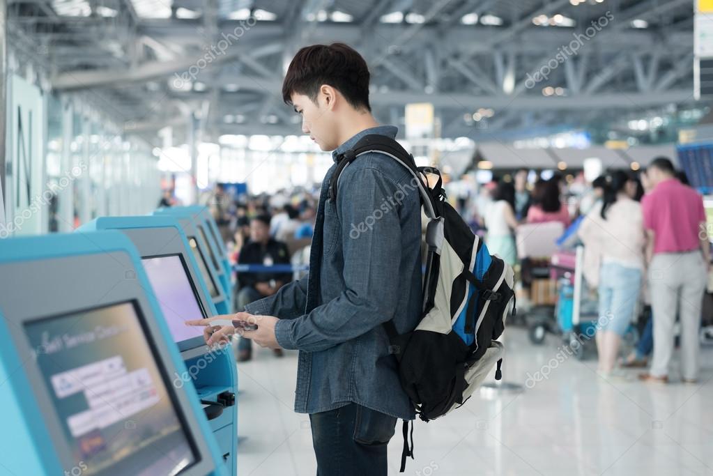 Young asian man using self check-in kiosks in airport — Stock Photo ...