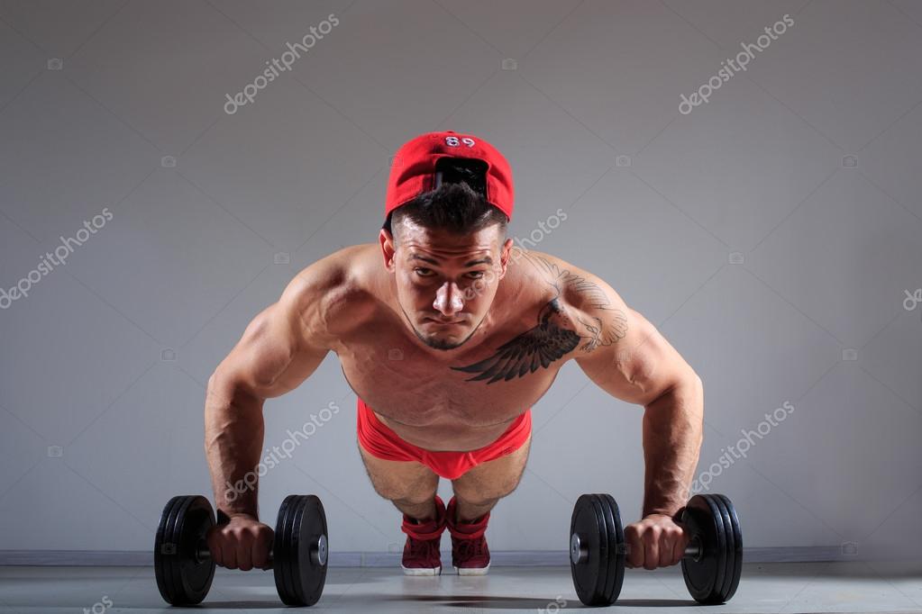 Muscular bodybuilder guy doing exercises with dumbbells Stock Photo by ...