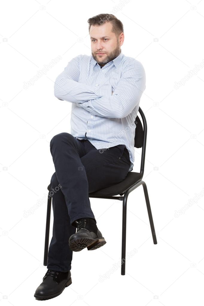 Hombre sentado en la silla. Fondo blanco aislado. brazos cruzados ...