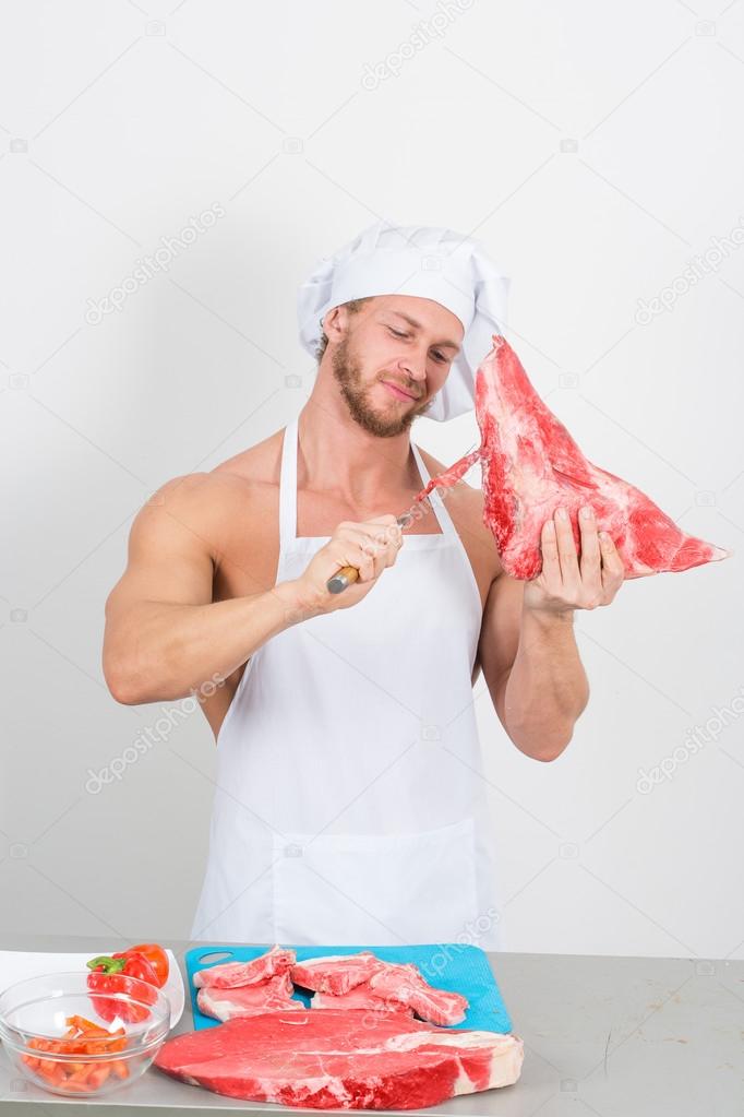 Chef bodybuilder preparing large chunks of raw meat. natural proteins ...
