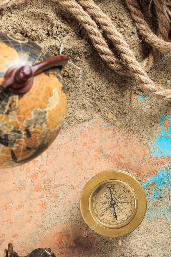 Set of nautical instruments, lying on the sand and old map. concept ...