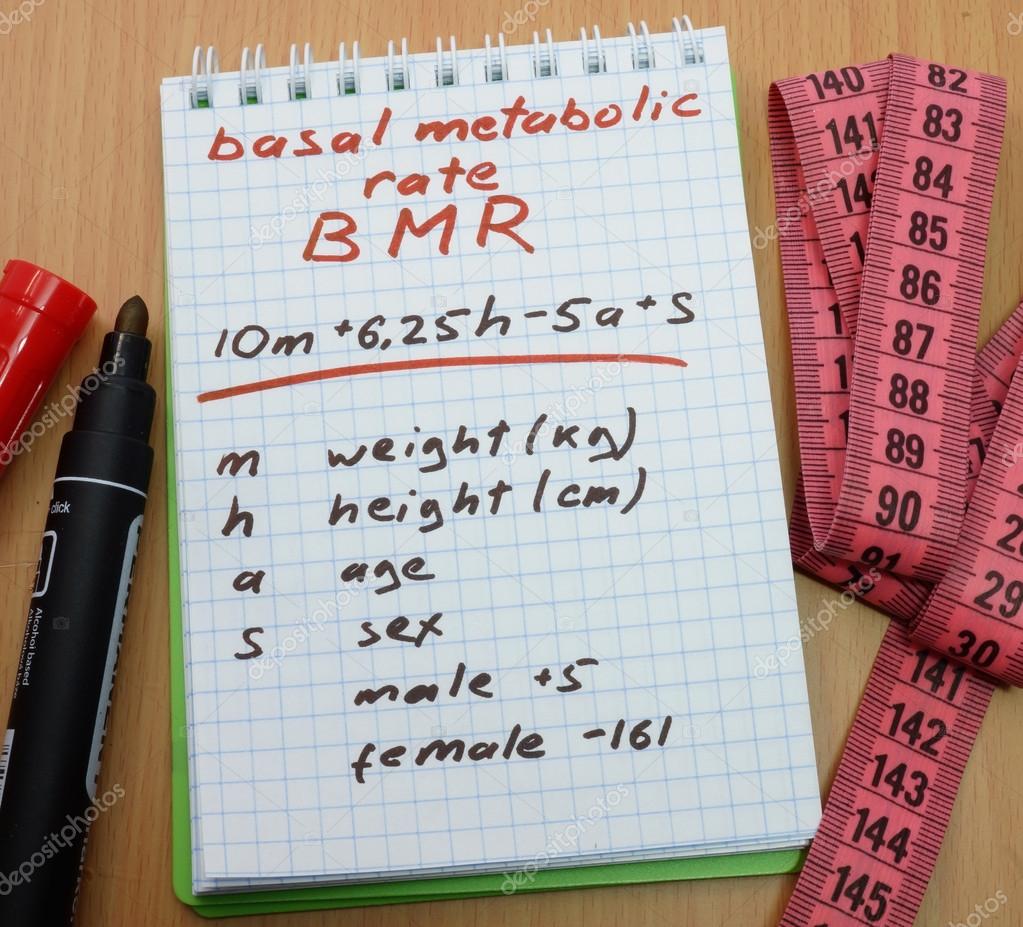 Measuring tape, a marker and a notepad with a calculation of bmr. Basal ...