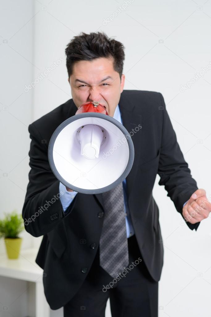 Angry businessman in an office, shouting on a megaphone — Stock Photo ...