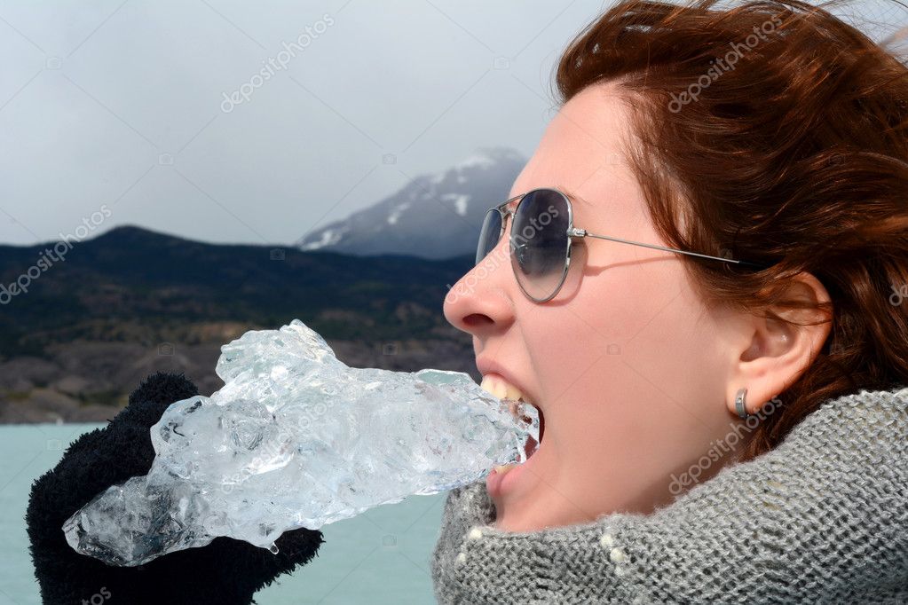 Young woman biting ice at a glacier. Happy woman in the Patagon — Stock ...