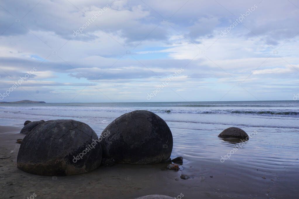 Las rocas de Moeraki son piedras redondas grandes únicas que mienten a lo largo de la playa de ...