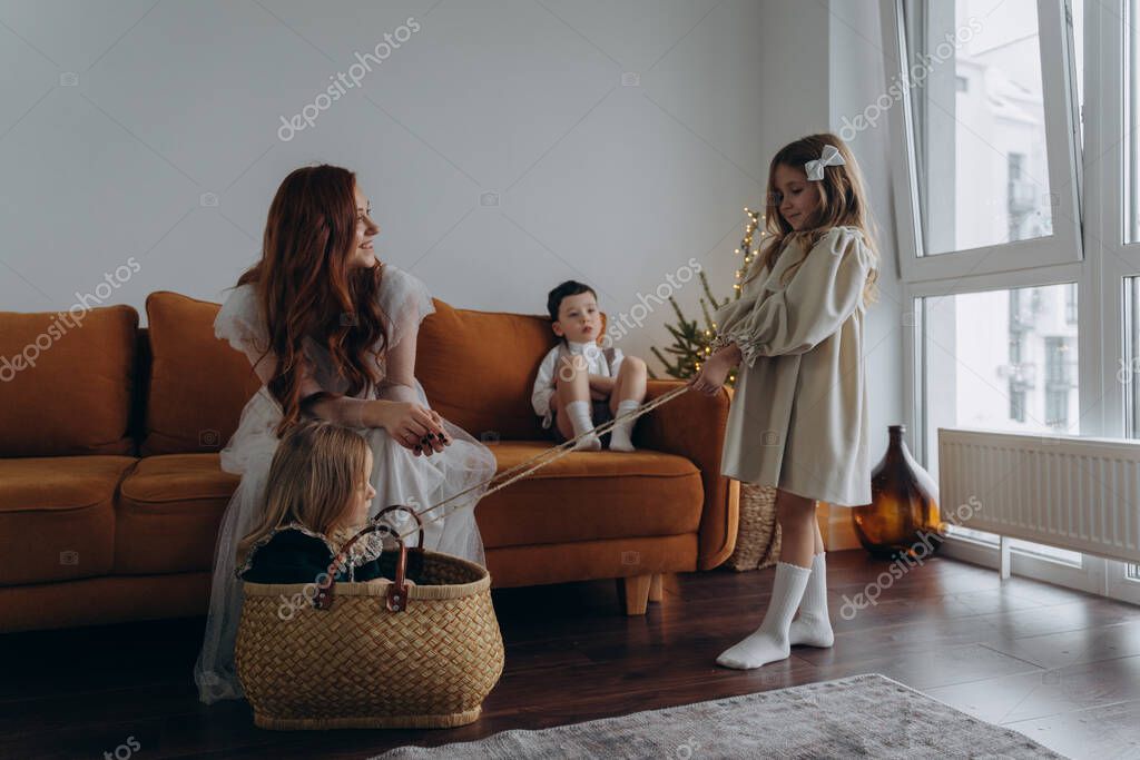 hermosa pelirroja vestida con un vestido blanco bohemio con sus hijas e ...