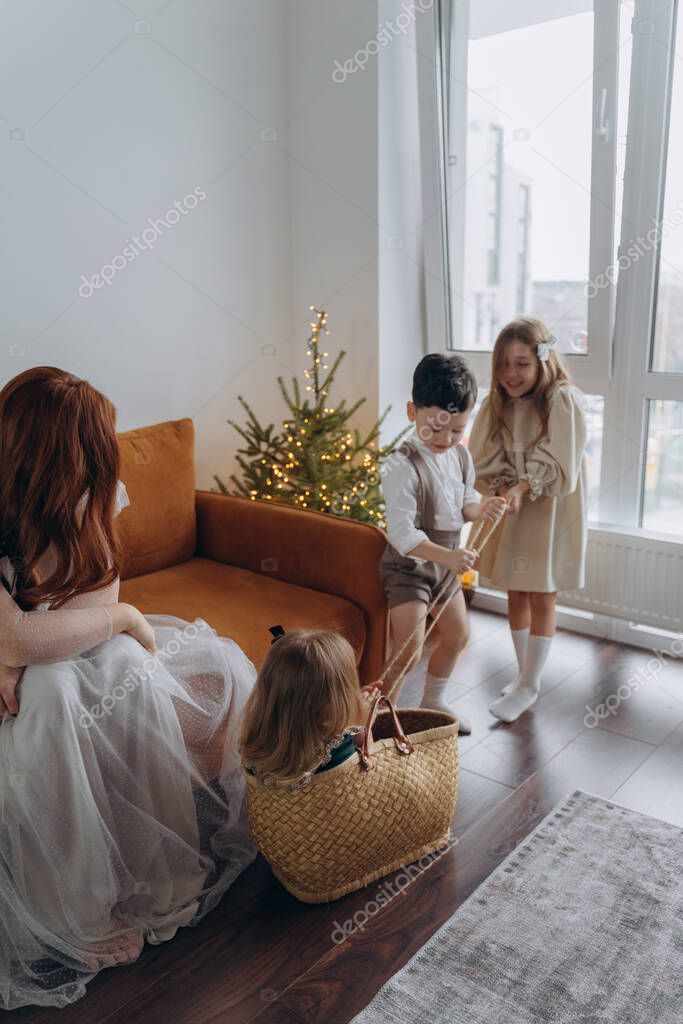 hermosa pelirroja vestida con un vestido blanco bohemio con sus hijas e ...