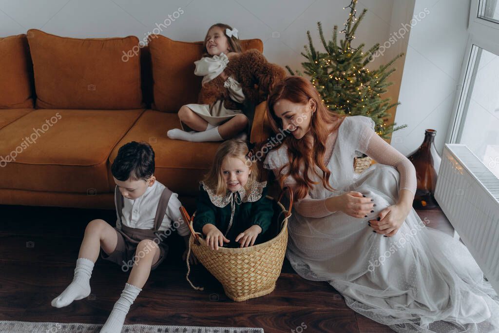hermosa pelirroja vestida con un vestido blanco bohemio con sus hijas e ...
