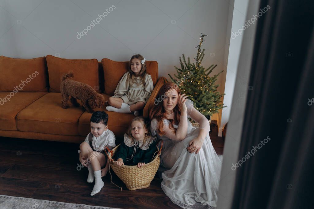 hermosa pelirroja vestida con un vestido blanco bohemio con sus hijas e ...