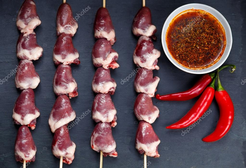 Ready to cook Duck Heart stringed on skewers BBQ with hot sauce and ...
