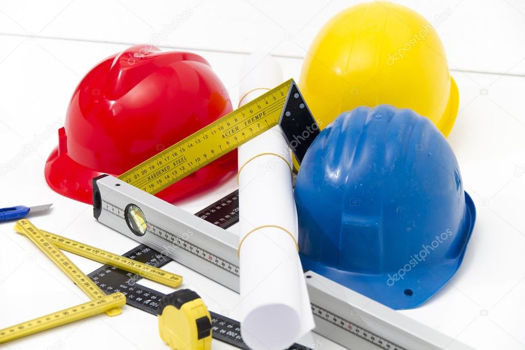 Colorful helmets and tools for construction drawings and buildin ...