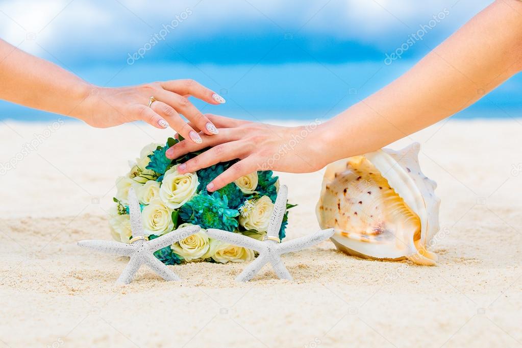 Male and female hands, two wedding rings with two starfish, wedd ...