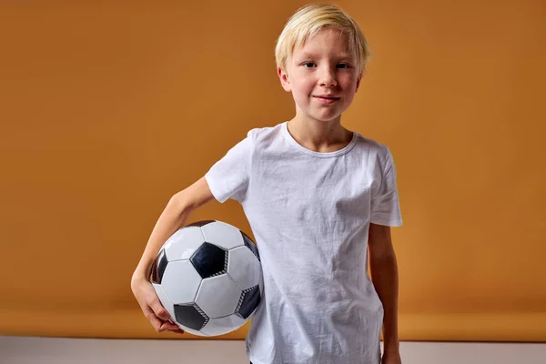 little caucasian football player with ball isolated in studio - Stock ...