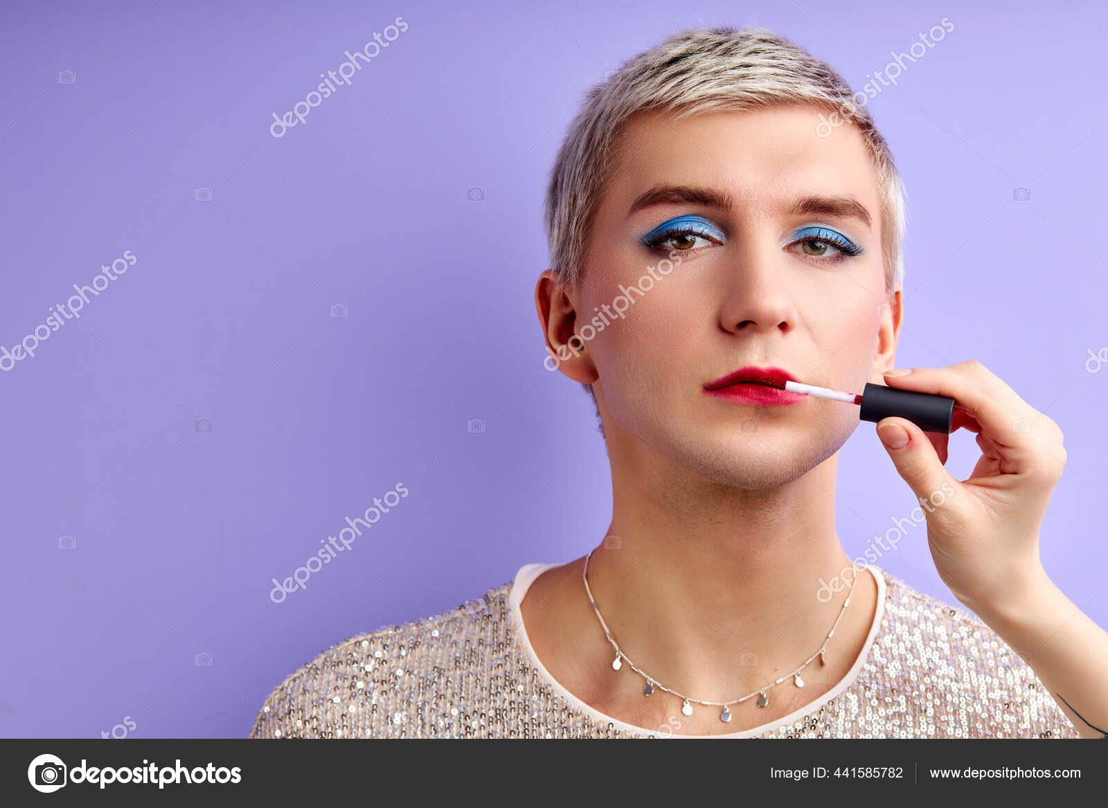 Effeminate man applying red lipstick on his lips Stock Photo by ...