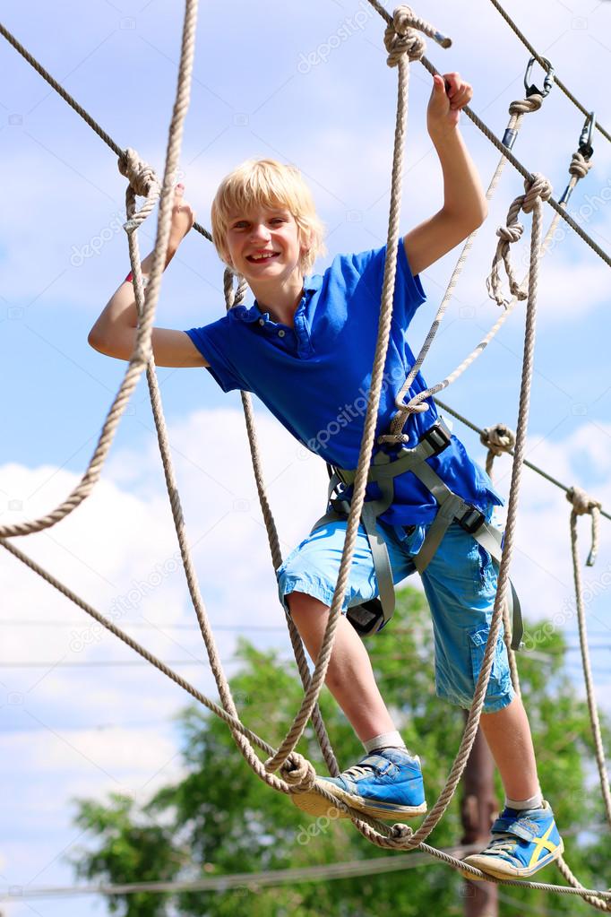 Boy climbing in adventure park Stock Photo by ©CroMary 113873428