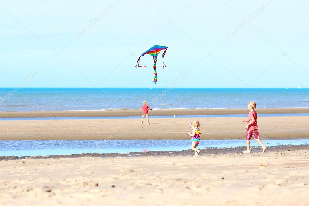Happy children playing with kite on the beach Stock Photo by ©CroMary ...