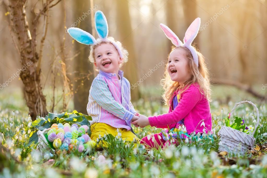 Kids on Easter egg hunt in blooming spring garden Stock Photo by ...