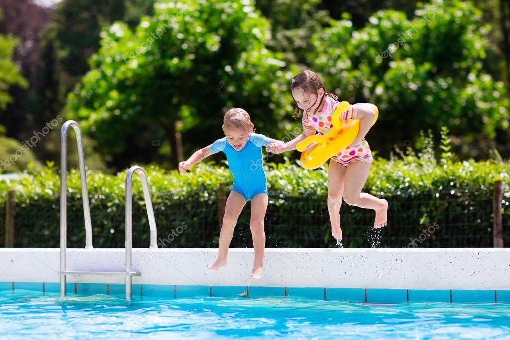 Kids jumping into swimming pool — Stock Photo © FamVeldman #119853634