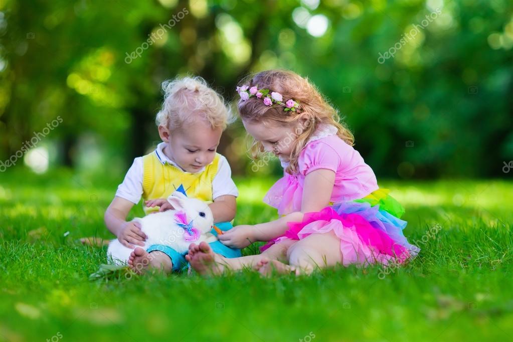 Kids playing with pet rabbit Stock Photo by ©FamVeldman 82031266