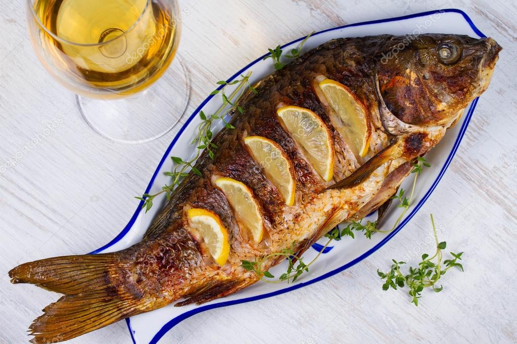 Carpa entera de pescado a la parrilla servida con ensalada y limón ...