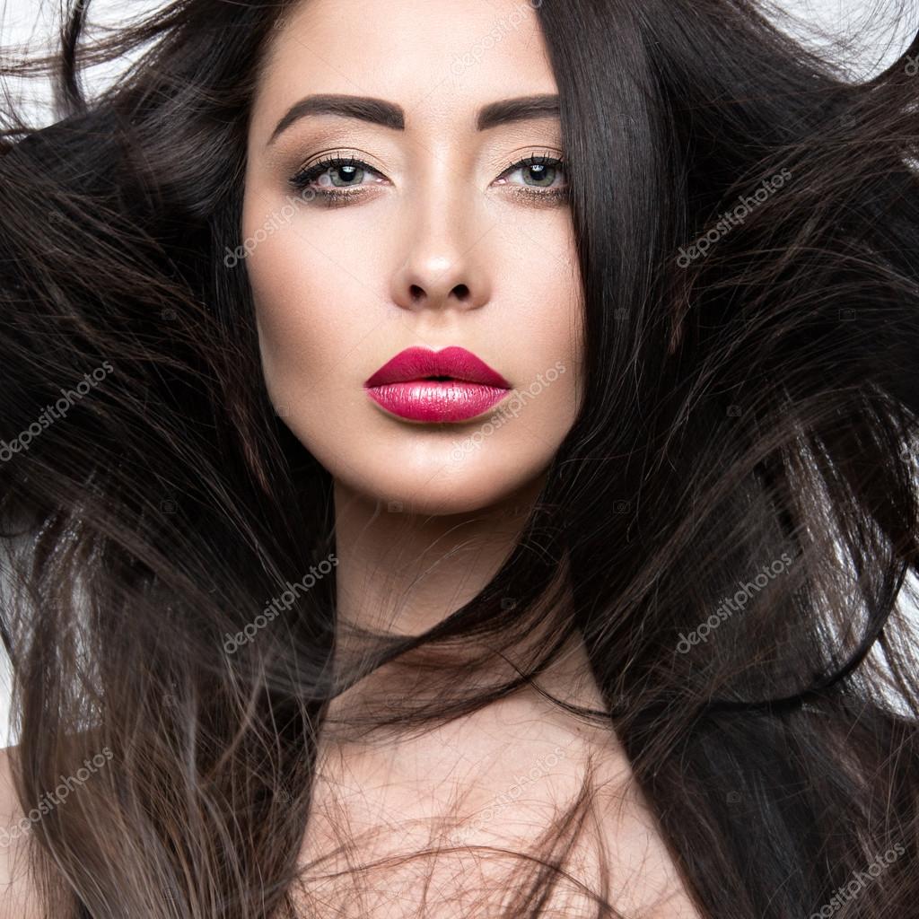 Beautiful girl with evening makeup, pink lips and the wind in hair ...